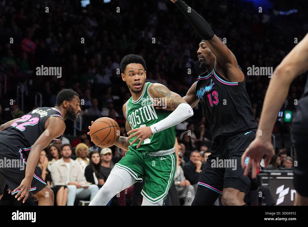Boston Celtics guard Anfernee Simons, center, is defended by Miami Heat ...