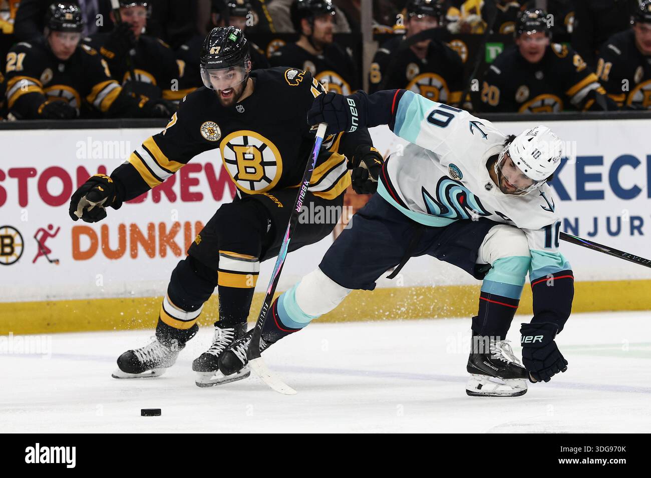 Boston Bruins' Mark Kastelic eyes a loose puck as he gets past Seattle ...