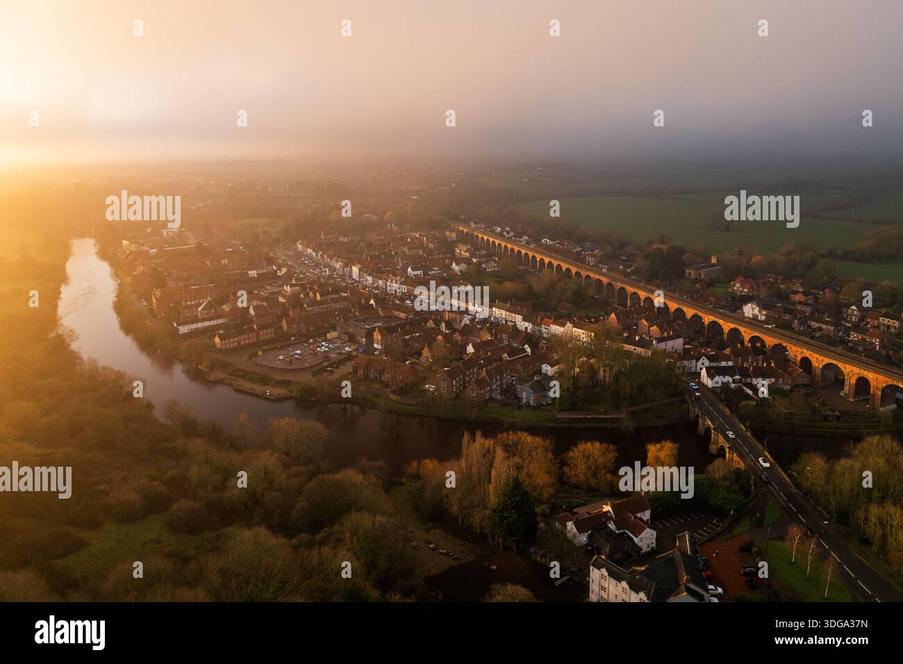 Aerial view of a river meanders through a town, bisecting the muted ...