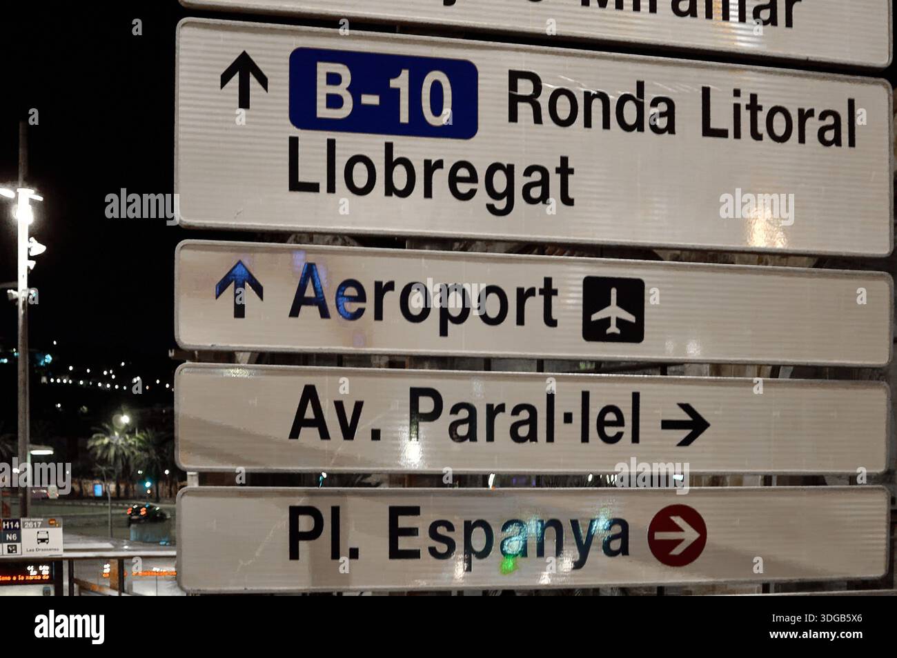 Night photography of stacked directional road signs in Barcelona ...