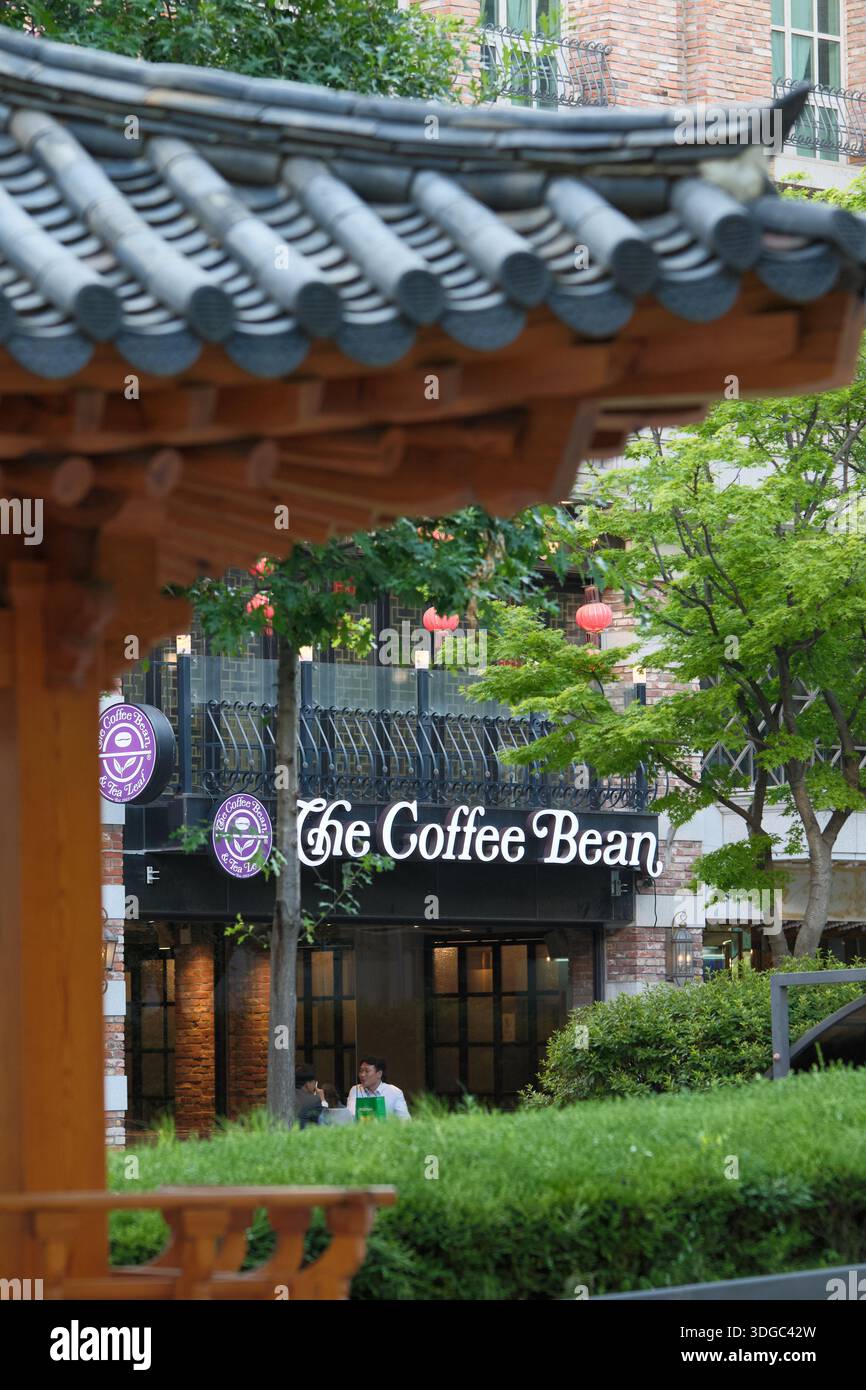 Traditional Korean hanok roof tiles in foreground with modern cafe ...