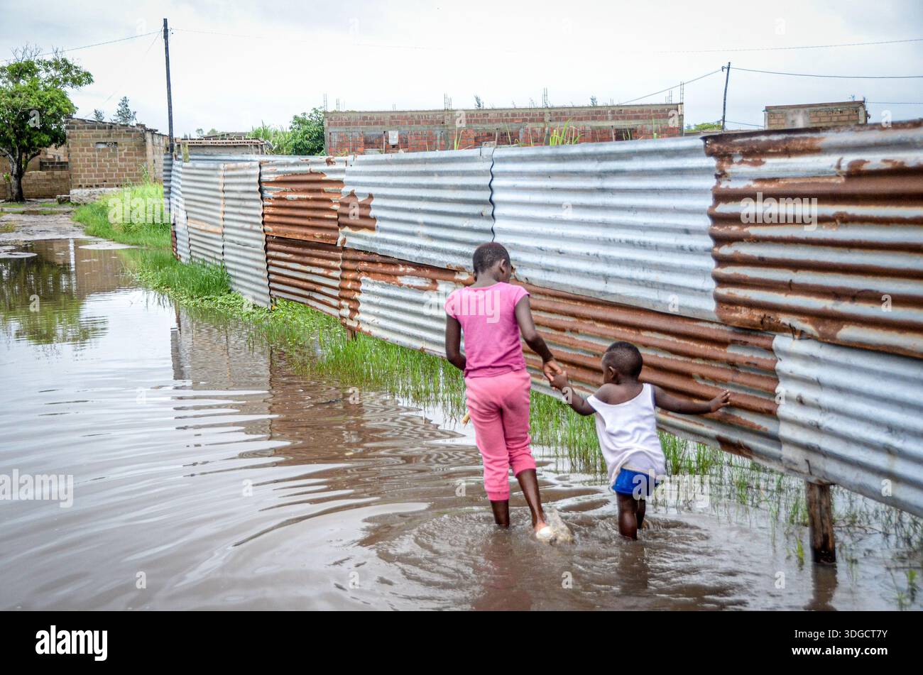 Children wade through floodwaters in a neighborhood in Maputo ...