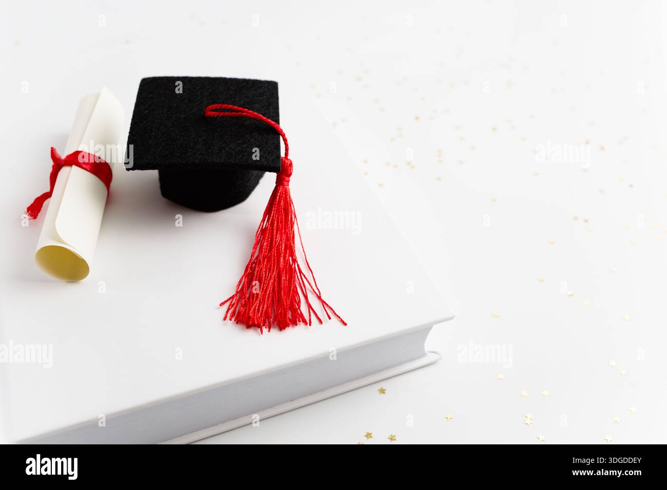 Graduation cap, rolled diploma, book celebrating education success ...