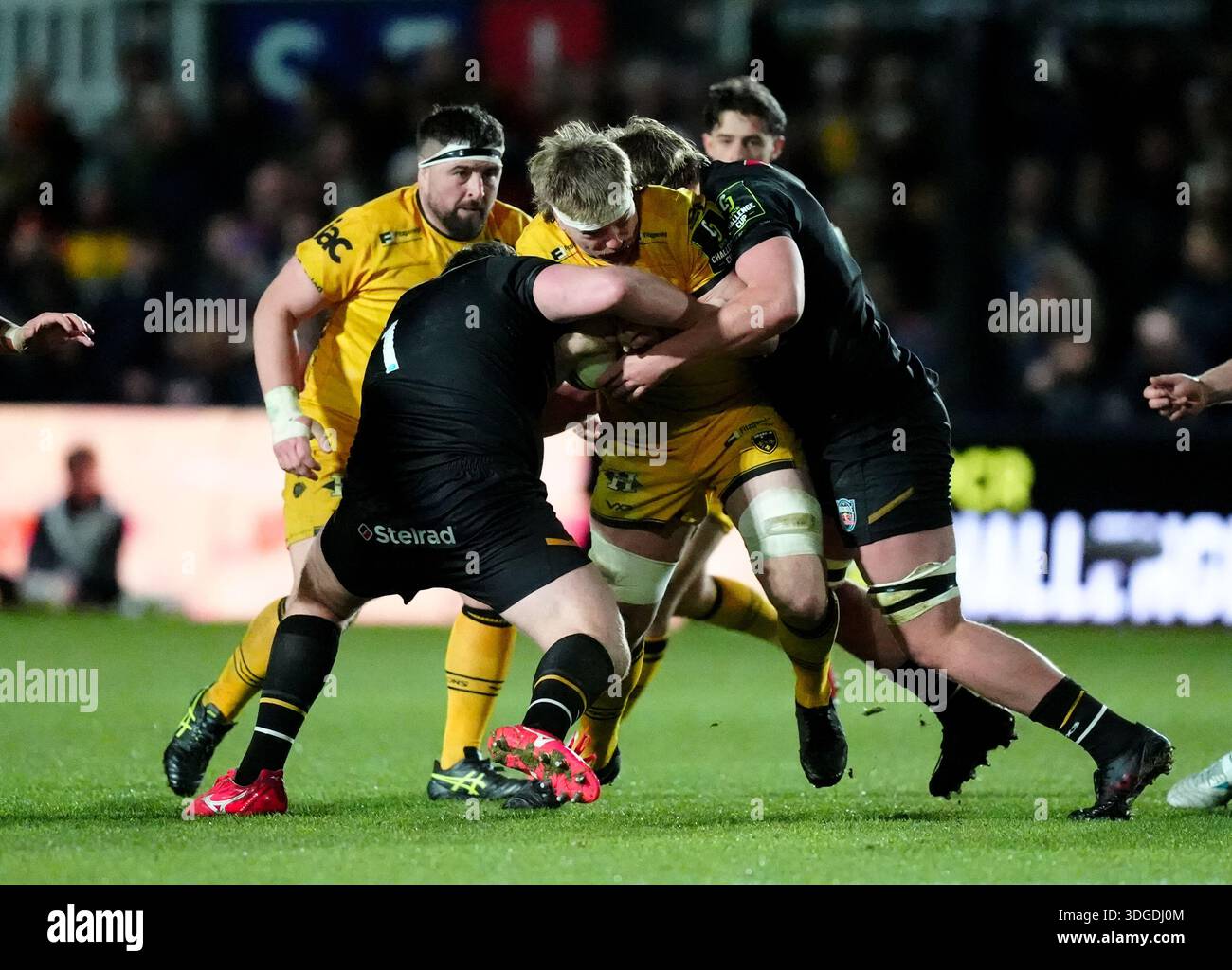 Dragon's Aaron Wainwright is tackled by Newcastle's Murray McCallum and ...