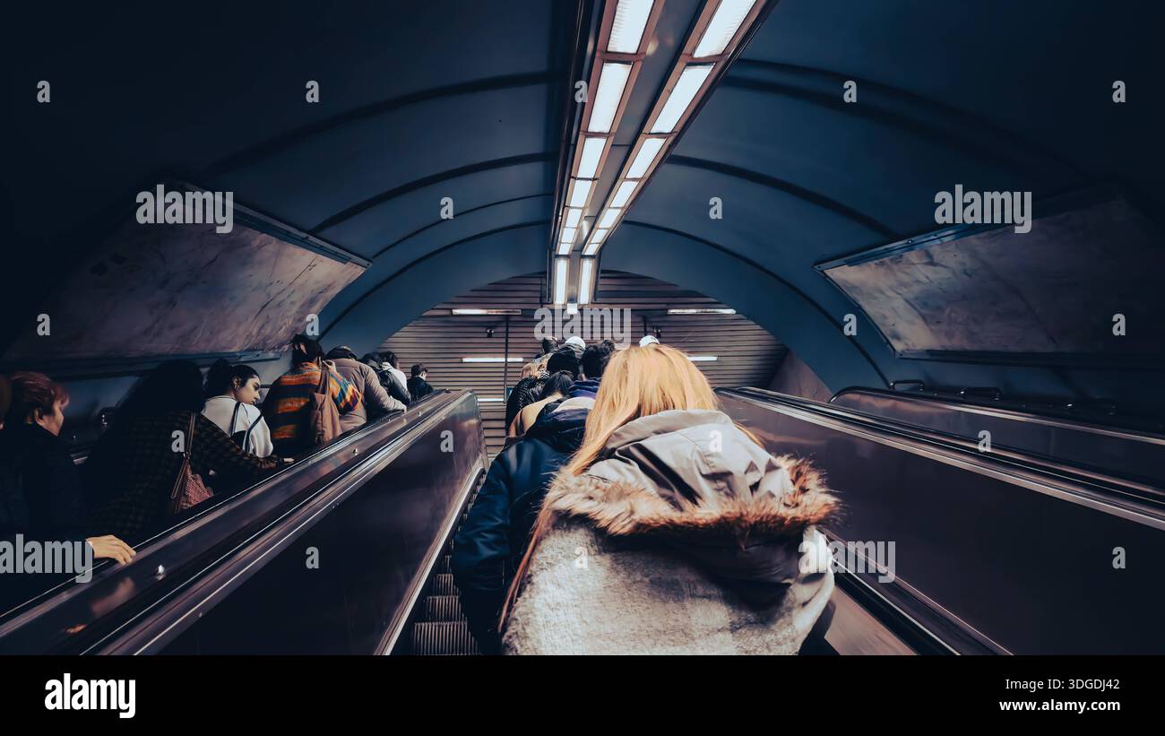 Passengers standing on the moving escalators Passengers standing on the ...