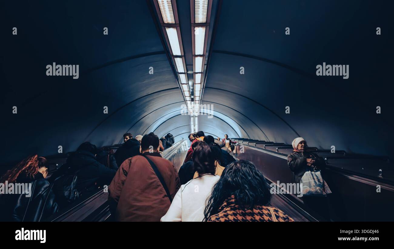 Passengers standing on the moving escalators Passengers standing on the ...