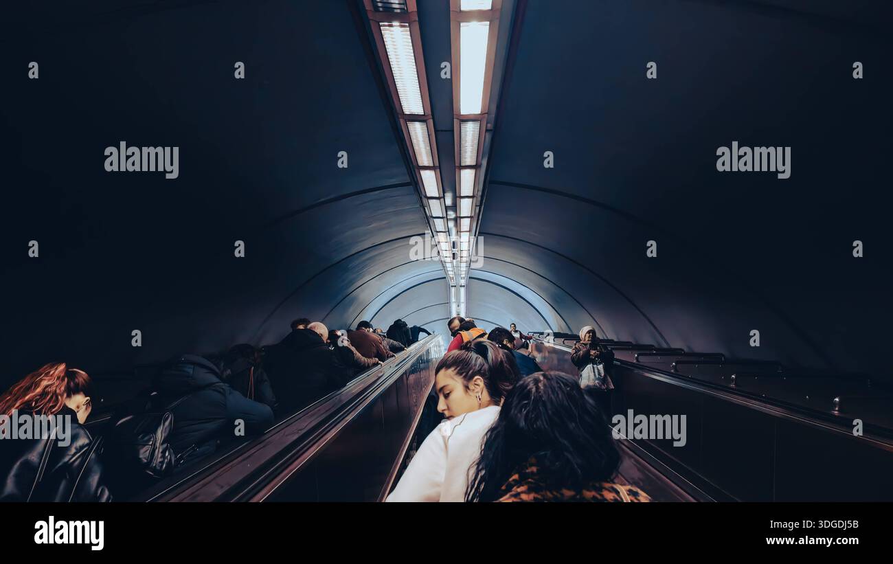 Passengers standing on the moving escalators Passengers standing on the ...