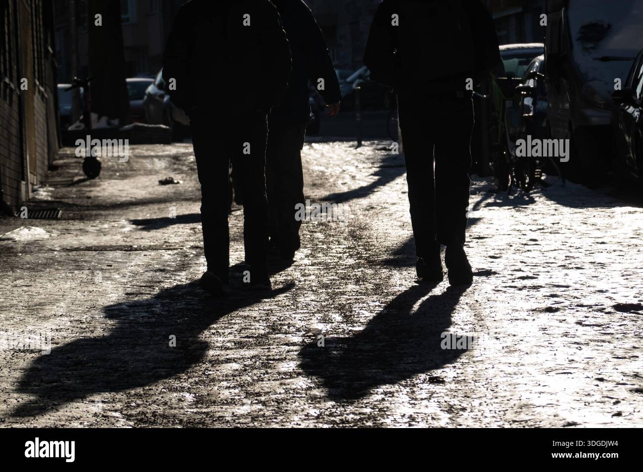 Menschen laufen auf dem Gehweg gedeckt mit Schnee und Eis in Berlin ...