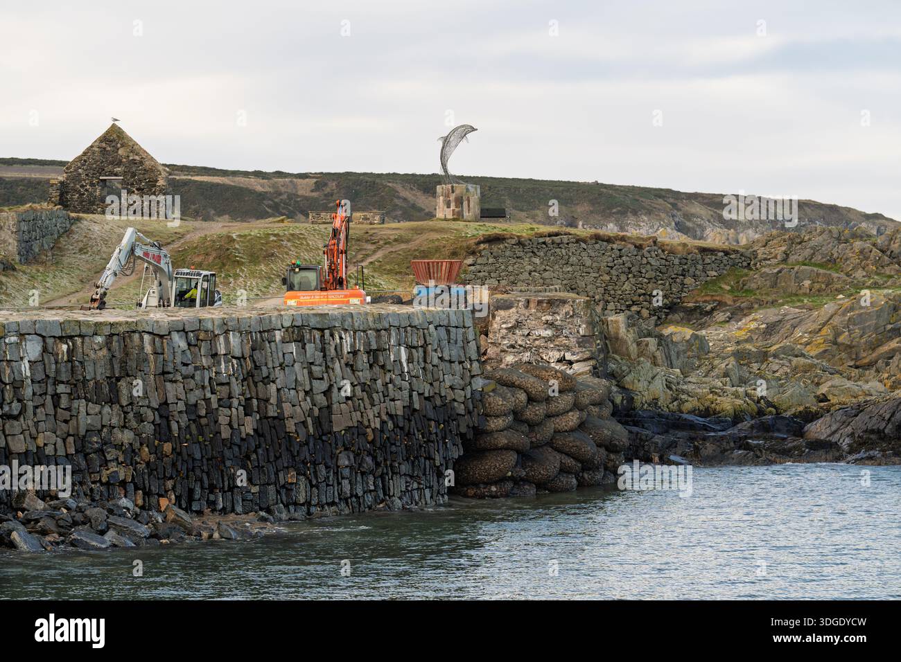 Storm damage at Portsoy Harbour's outer pier is being repaired. Workers ...