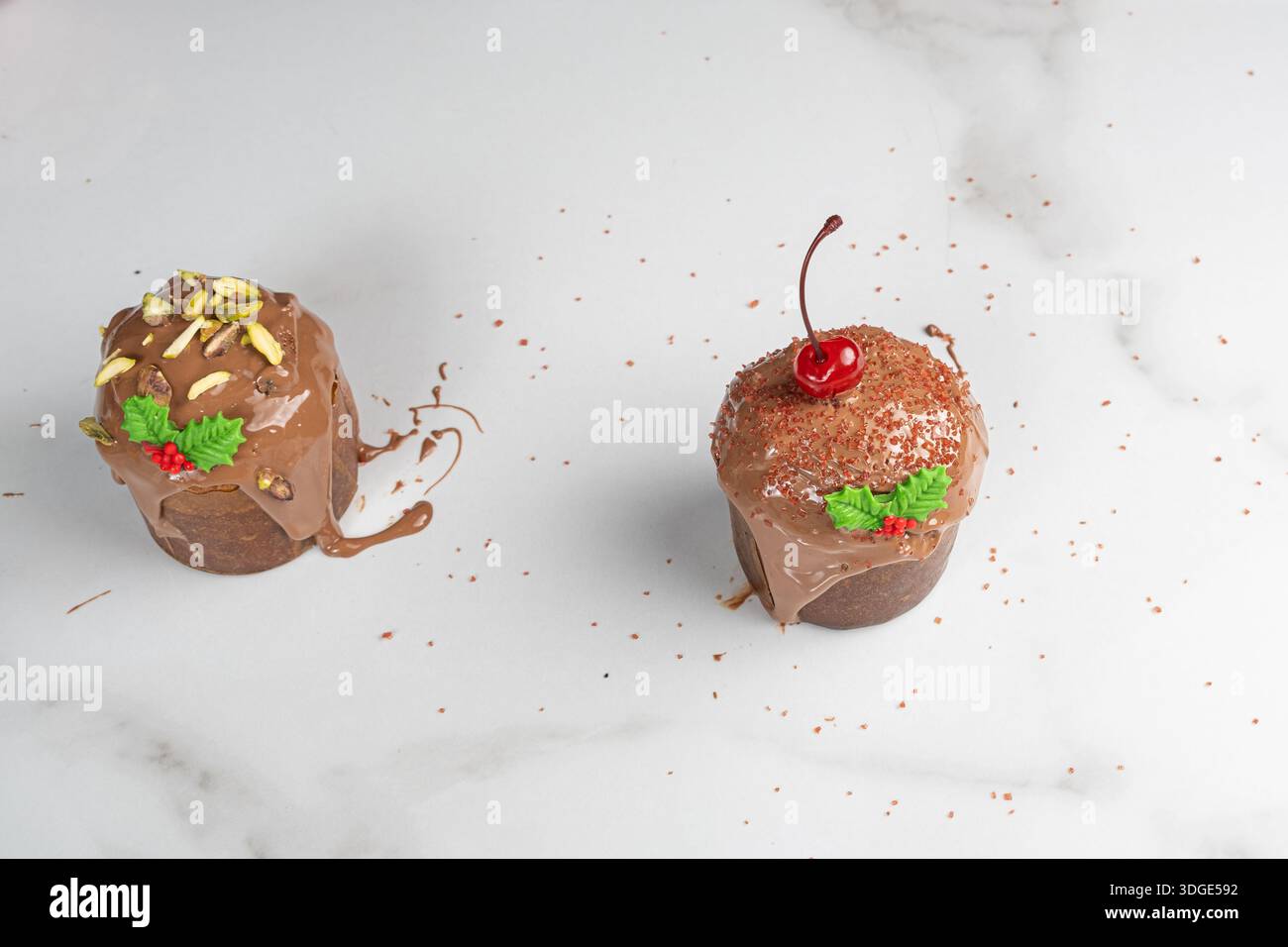 Two small panettone cakes covered in melted chocolate, pistachios ...