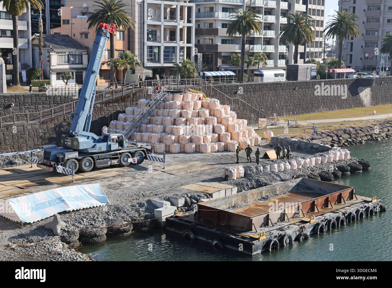 Sandbags are piled up on a bank of the Oyodo River to dispose of ...