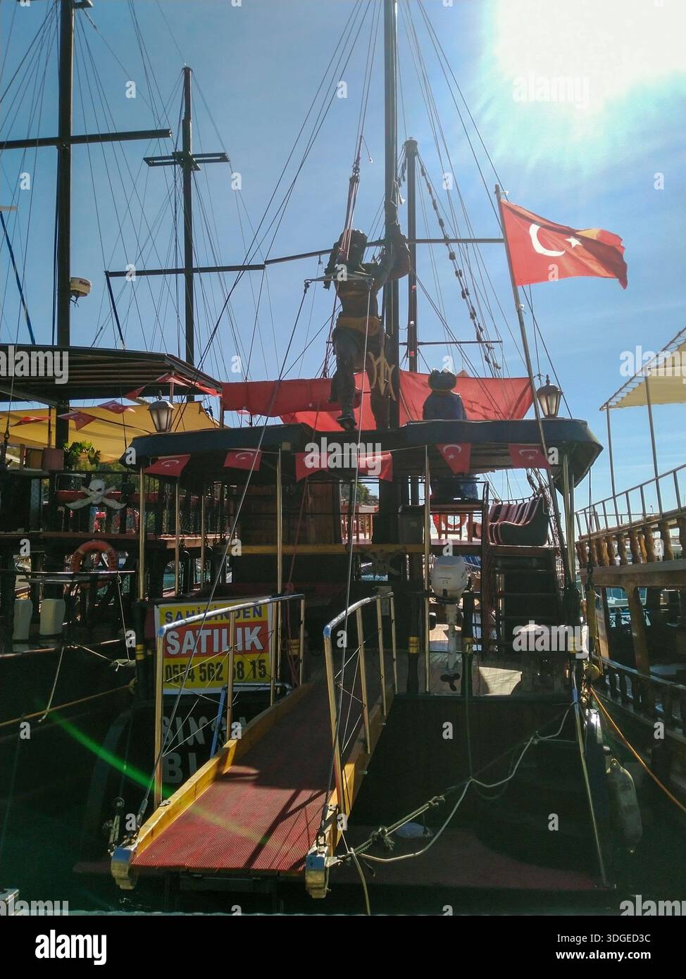 Decorative pirate ship with large statue and Turkish flags docked in ...