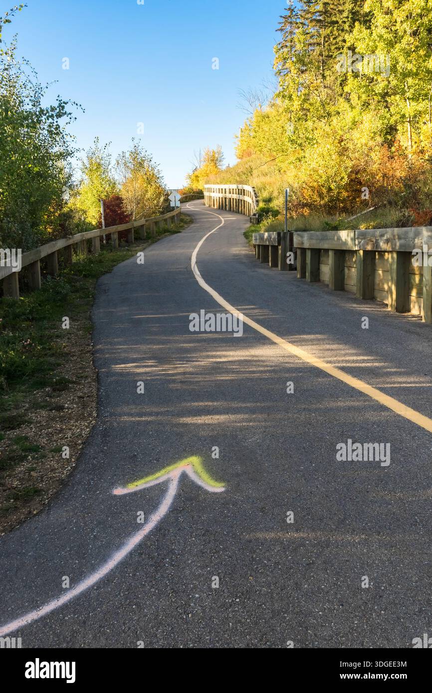 Winding paved trail marked with median yellow line framed with retained ...