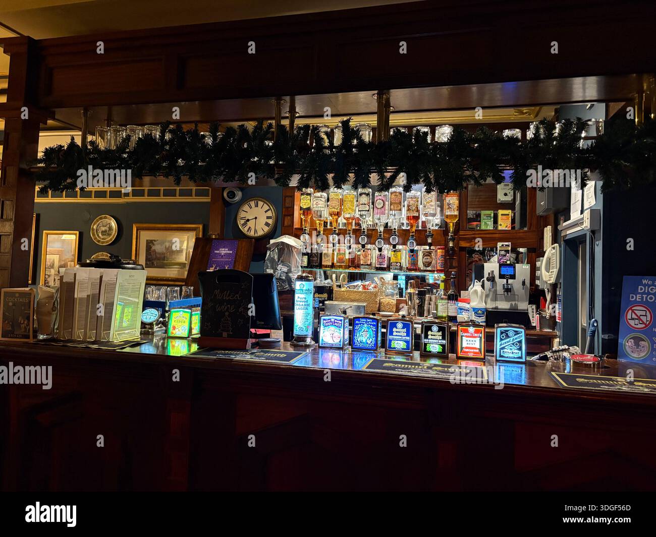 Traditional British pub bar interior with illuminated beer taps ...