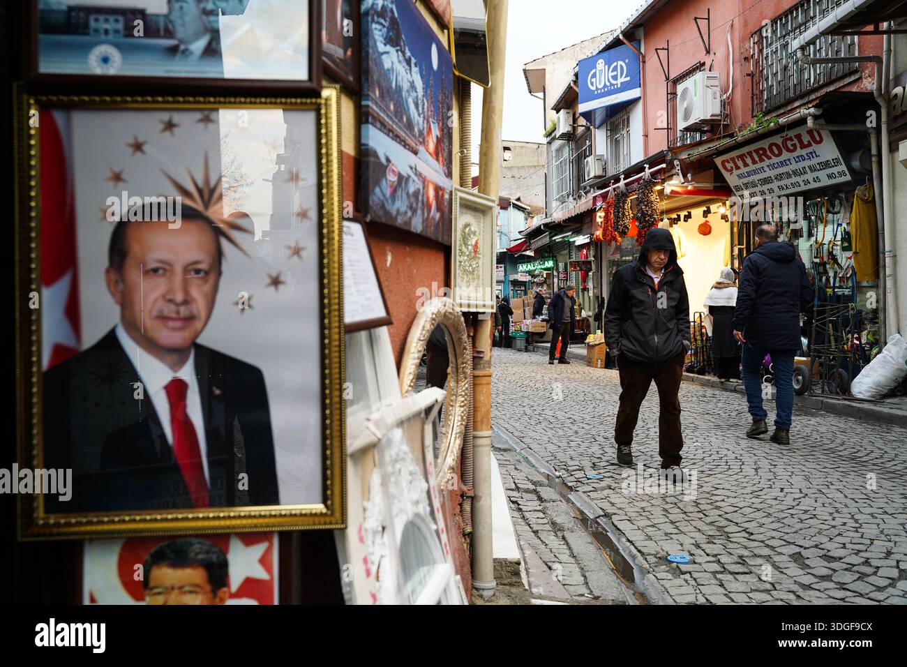 People walk through a market as a portrait of Turkish President Recep ...