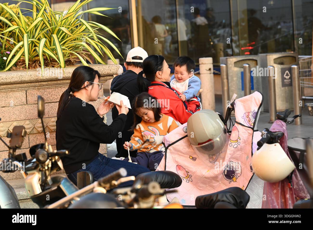 A general view showing a baby, girl and parents resting on the outdoor ...
