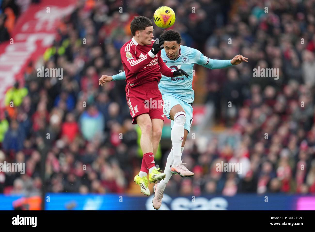 Burnley's Bashir Humphreys, right, and Liverpool's Milos Kerkez jump ...