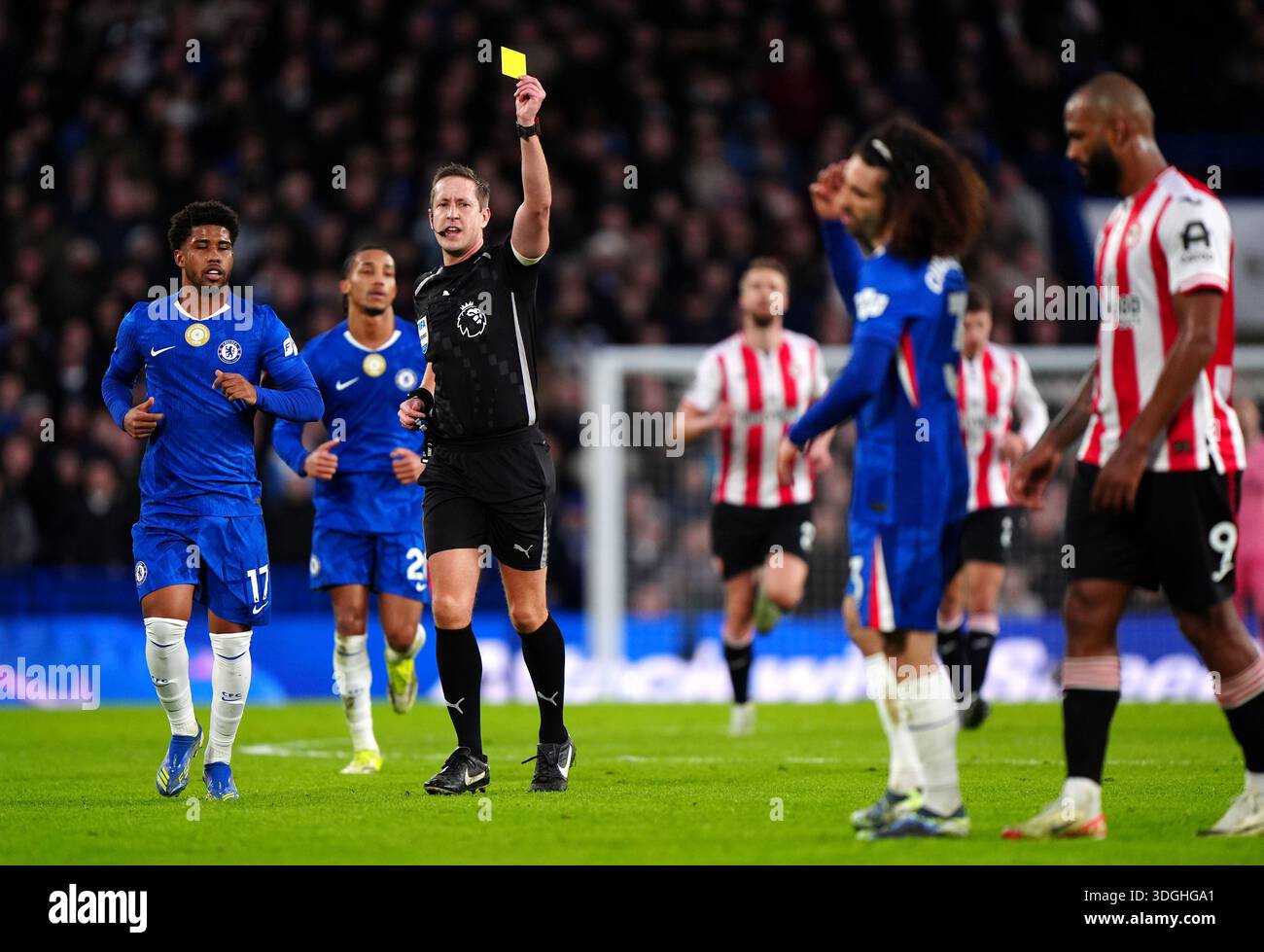 Referee John Brooks shows a yellow card to Chelsea's Marc Cucurella ...