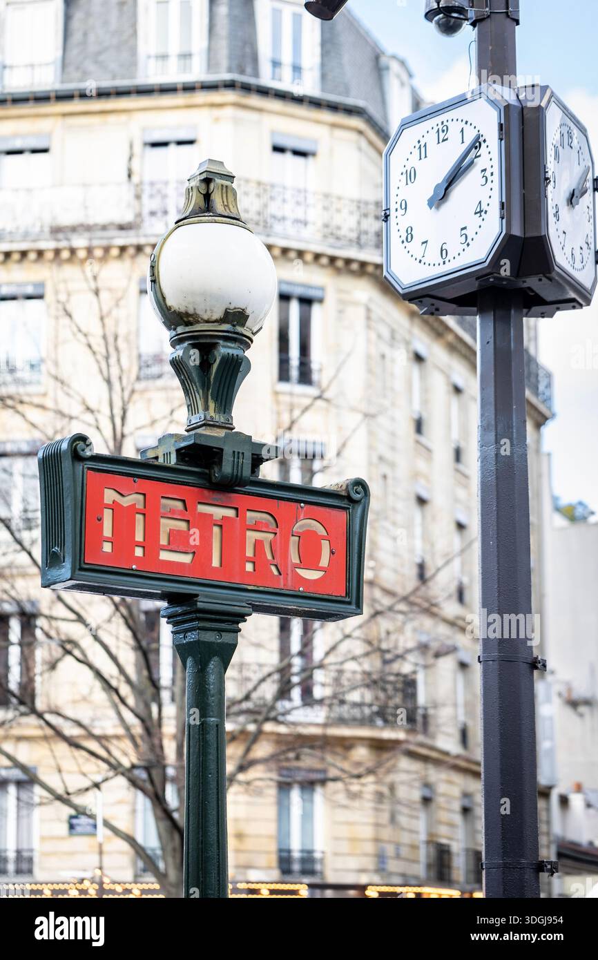 A classic Val d'Osne style Metro entrance sign and a large public clock ...