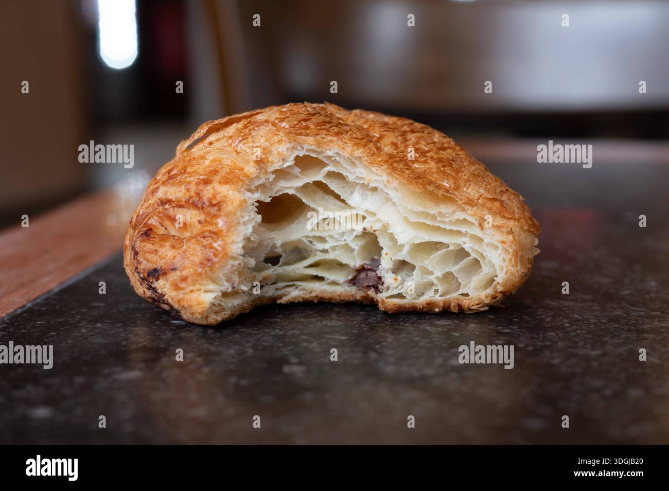 Close-up of a partially eaten pastry with visible puff pastry layers ...