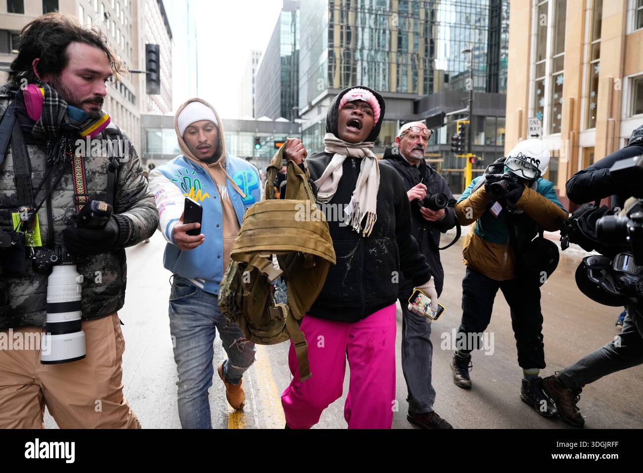 A pro-immigration protester lifts up Jake Lang's vest after an ...