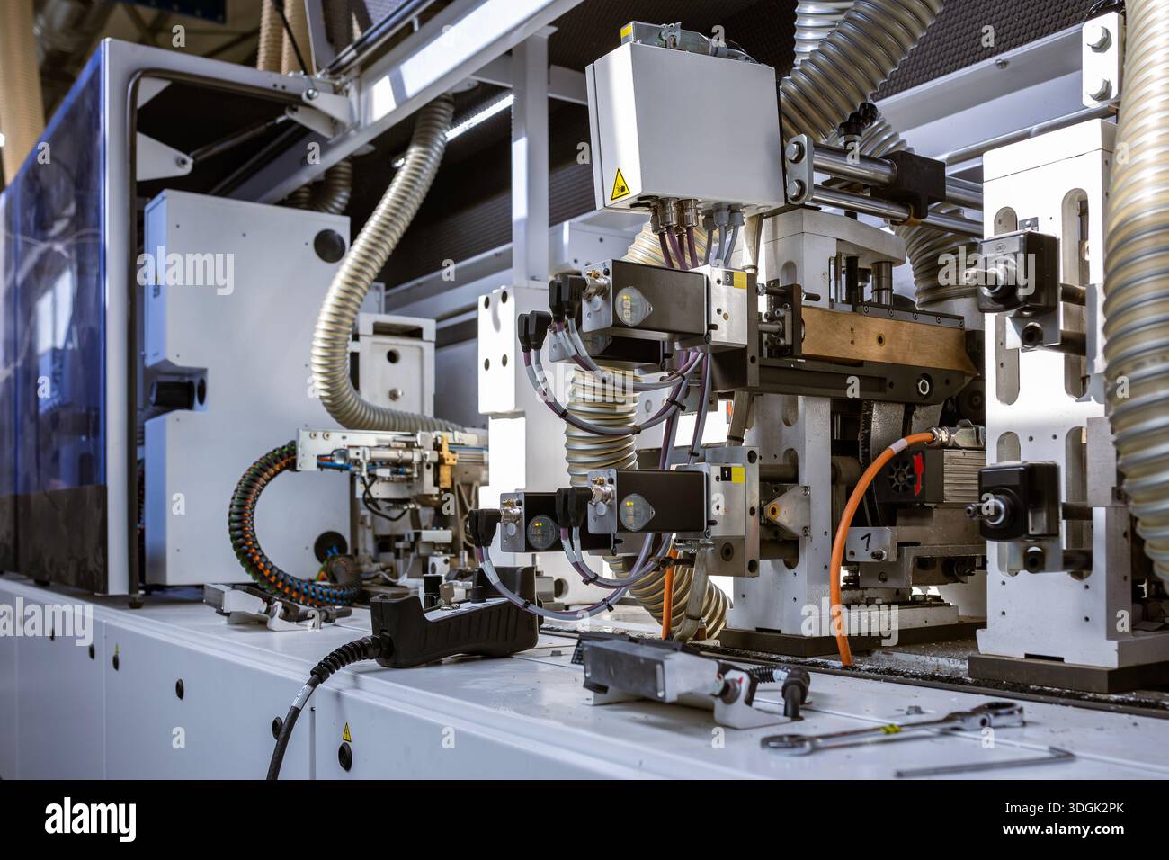 A close-up view of the internal mechanics of an automated edge banding ...
