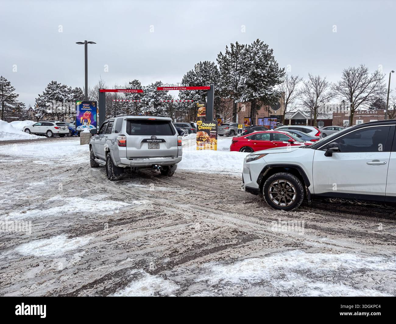 Cars line up in a snow-covered drive-thru lane at a McDonald's fast ...