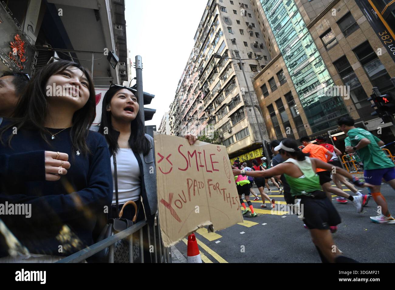 Two ladies cheer to the runners in the Hong Kong Marathon at Wan Chai ...