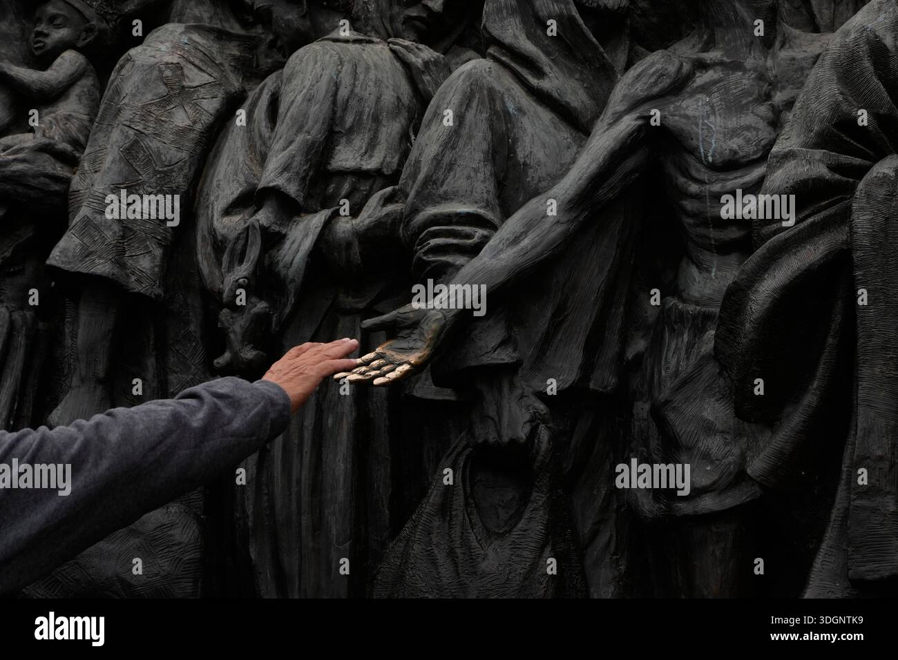 A man touches the bronze sculpture "Angels Unawares," by Canadian ...
