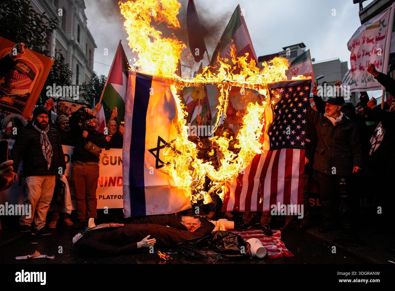 People burn U.S. and Israel flags during a rally in support of the ...