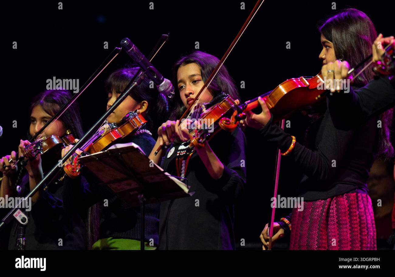 A team of young violinists performs on stage with famous violinist ...