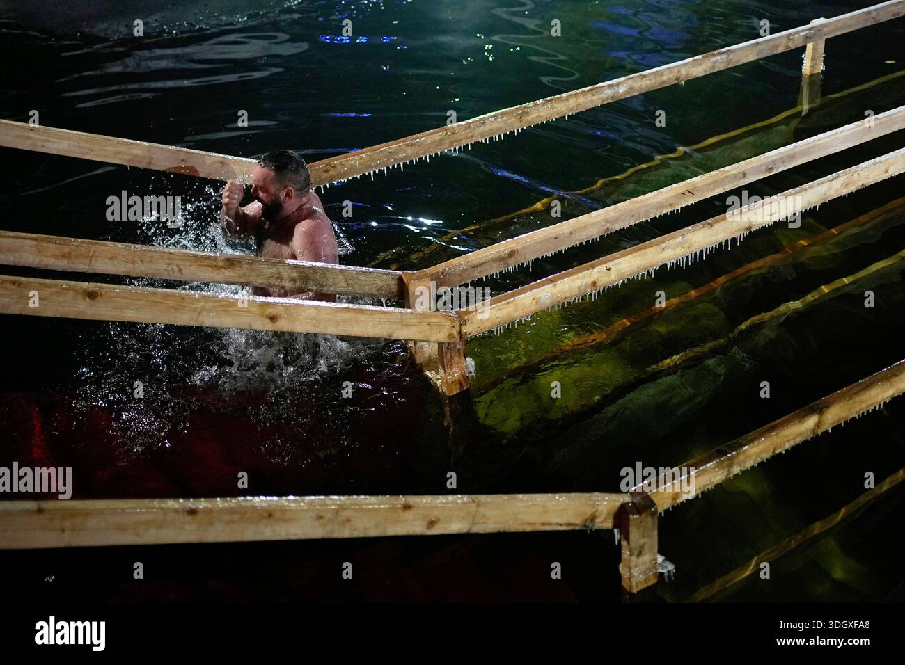 A man plunges into icy water to celebrate the Orthodox Epiphany at the ...