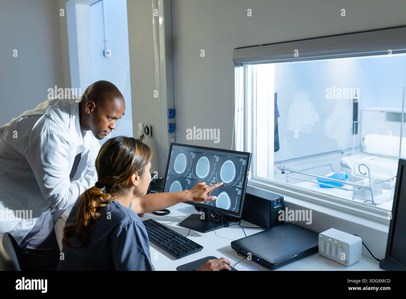 African American physician and tech in lab coat and scrubs reviewing ...