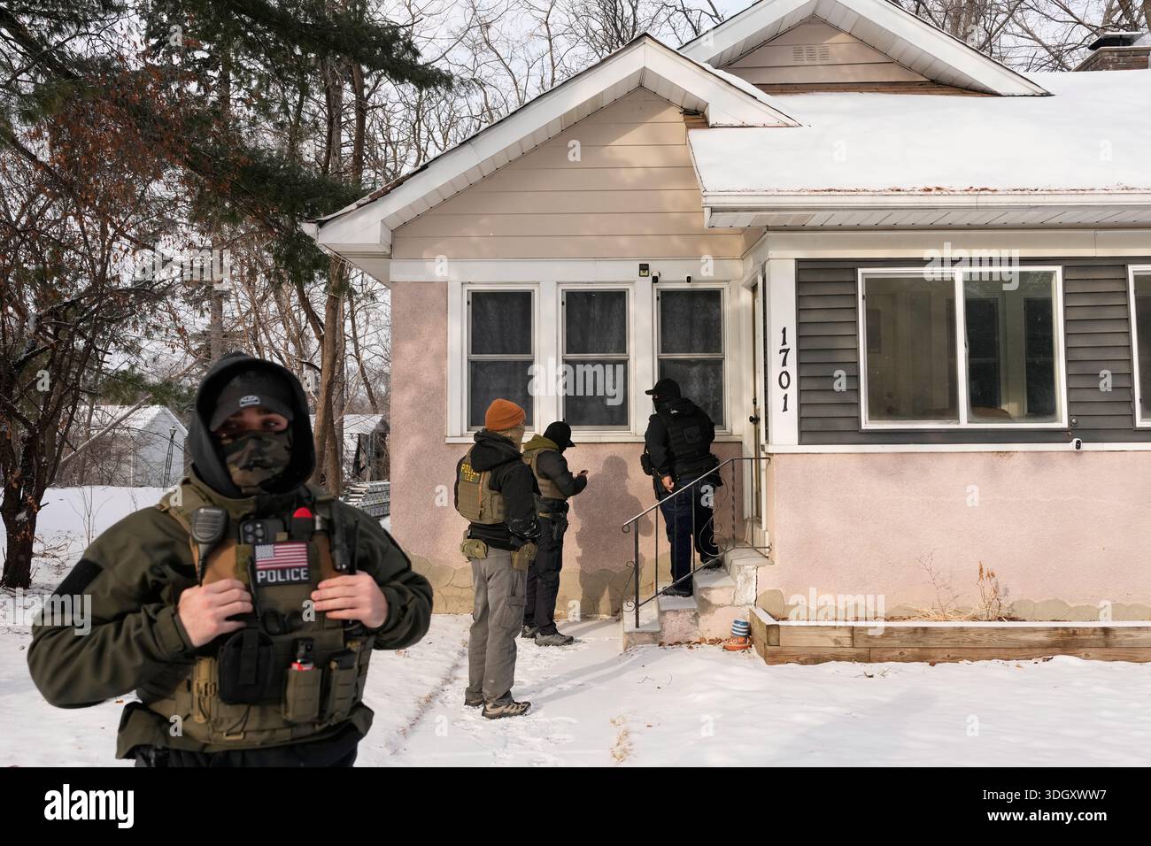 Federal law enforcement officers knock on the door of a house on Sunday ...