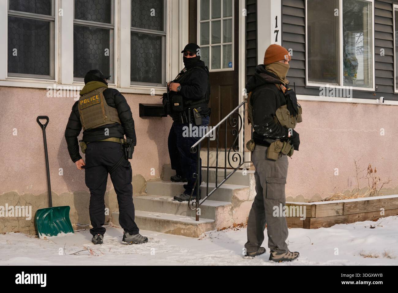 Federal law enforcement officers knock on the door of a house on Sunday ...