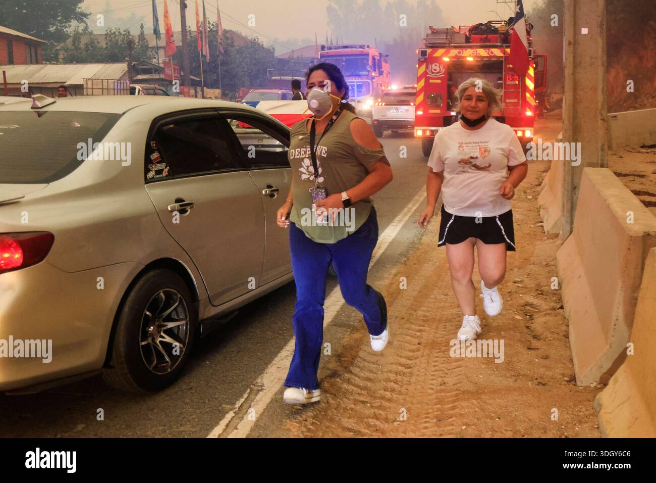 Women run as a wildfire in Concepcion, Chile on Jan. 18, 2026. (Photo ...