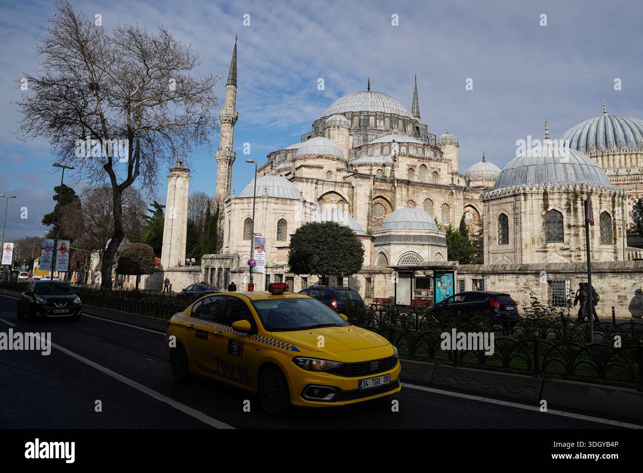 A taxi drives along the street in front of the Shehzade Mosque in ...
