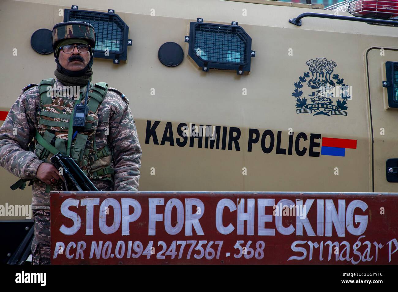 Indian paramilitary soldier stands alert at a checkpoint during a ...
