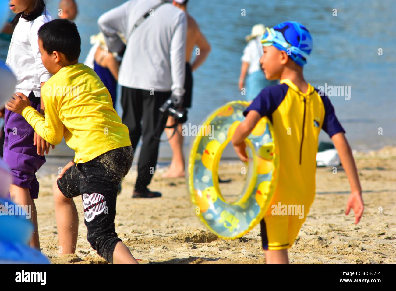 Tourists enjoy warm winter at Dadonghai beach in Sanya City ...