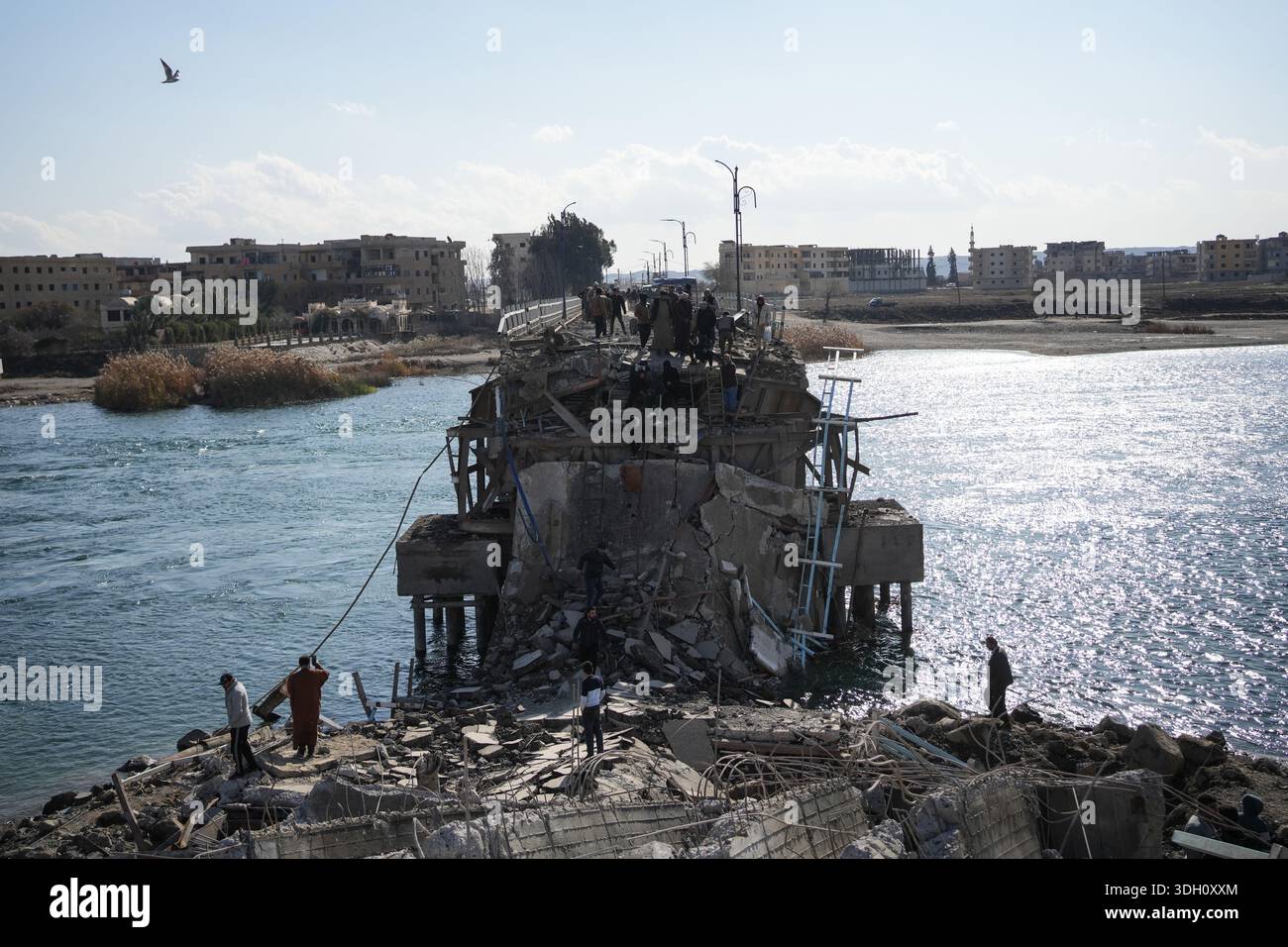 Ar Raqqah, Syria. 19th Jan, 2026. People cross the bridge connecting Ar ...
