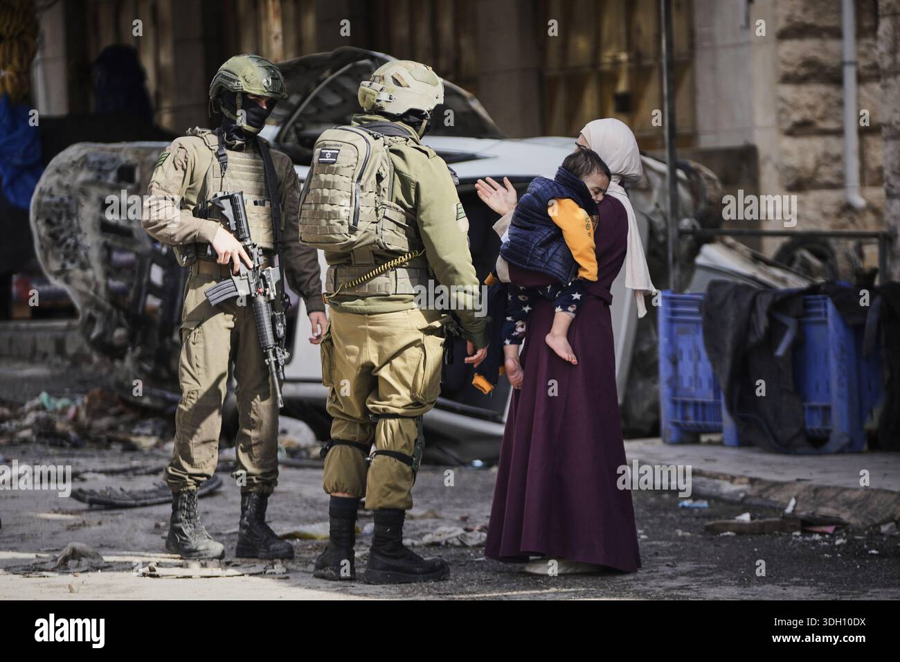 A Palestinian woman asks Israeli soldiers for access to her home during ...