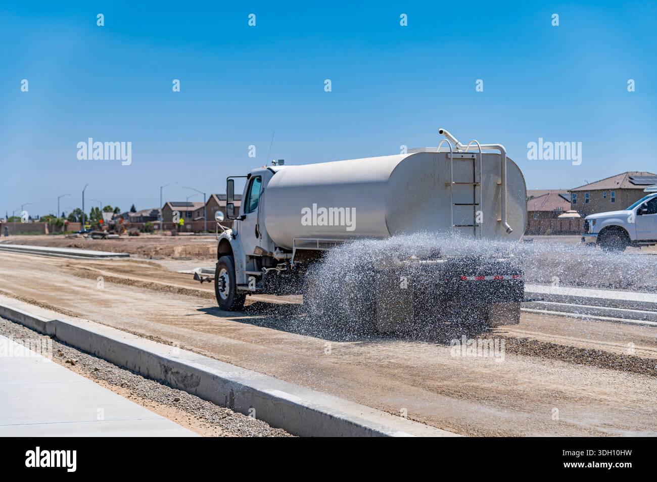 Watering machine. Road construction. Repair Stock Photo - Alamy