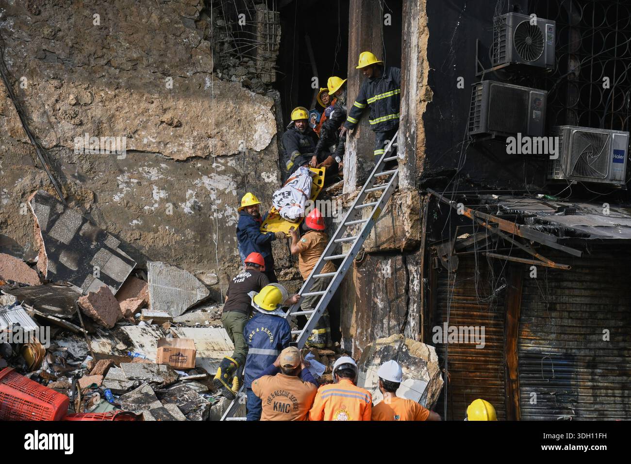 Firefighters transport a body after recovering from the rubble of a ...