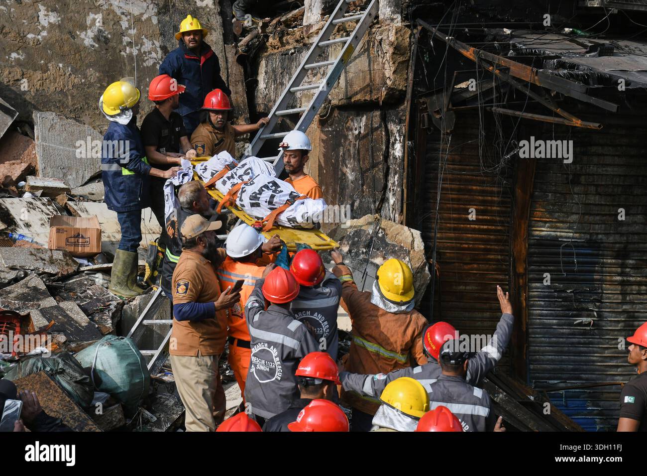 Firefighters transport a body after recovering from the rubble of a ...