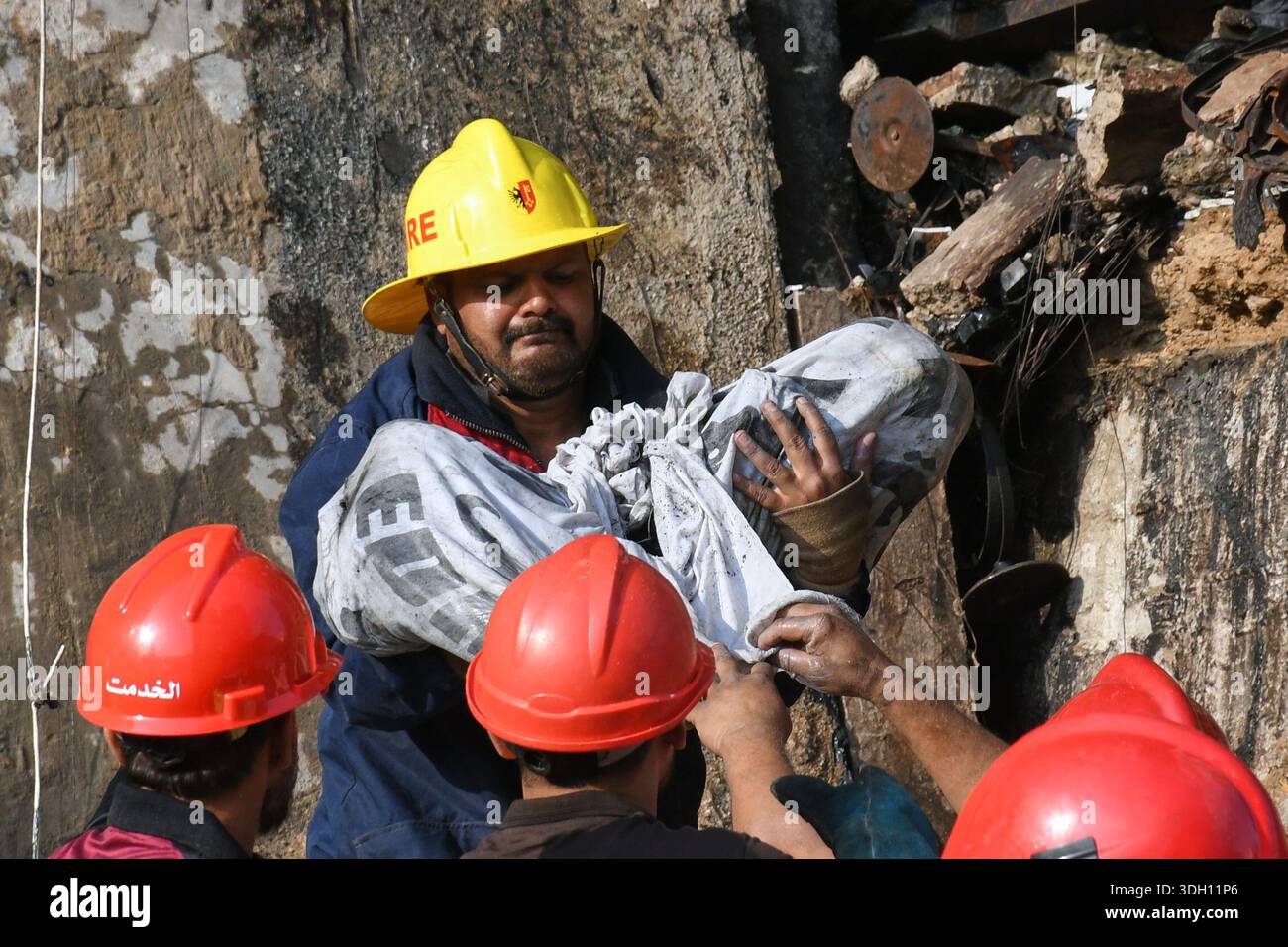 A firefighter carries remains of the victims after recovering from the ...
