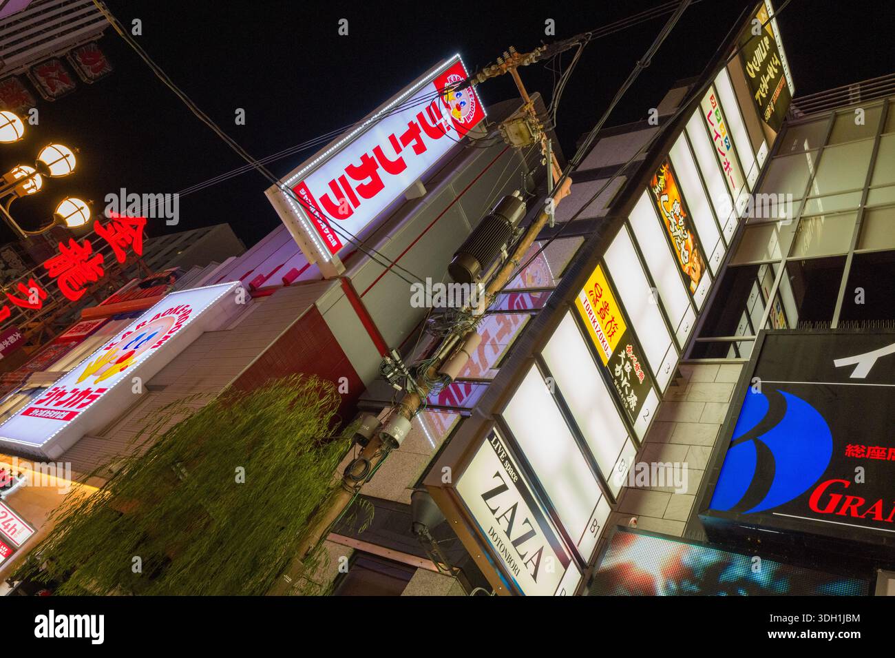 Osaka, Japan - November 5, 2023: View of brightly lit storefronts and ...