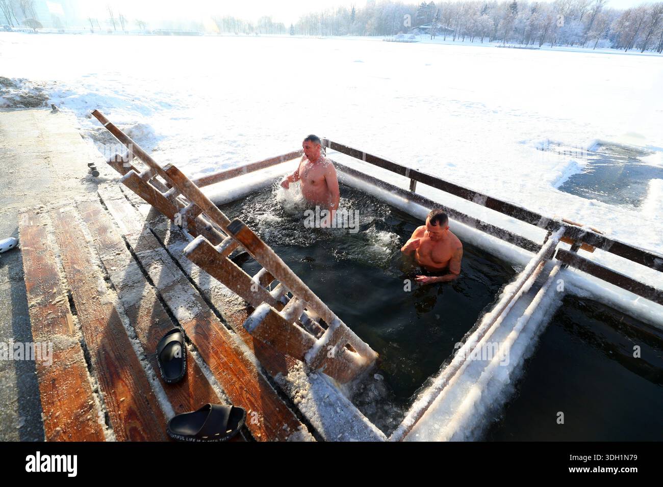 Minsk, Belarus. 19th Jan, 2026. Two men take a dip in the icy water ...