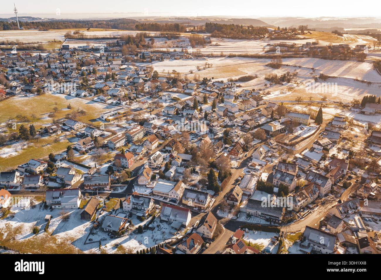 Wide settlement in winter with snow-covered roofs and fields in ...