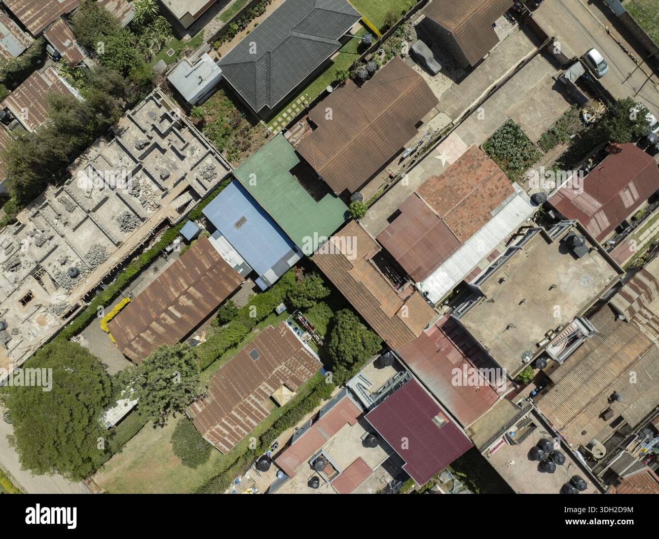 Aerial view of a vibrant urban tapestry of rooftops and verdant patches ...