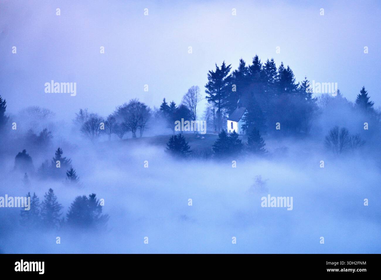 The small chapel of Oberreifenberg is surrounded by fog near Frankfurt ...